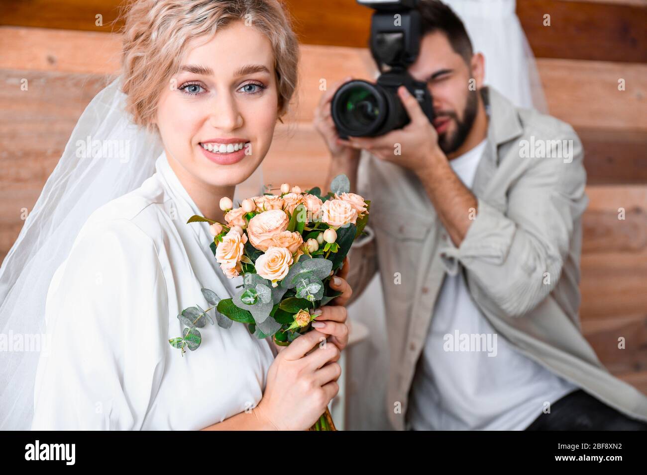 Photographer taking bride getting ready photos in studio Stock Photo ...