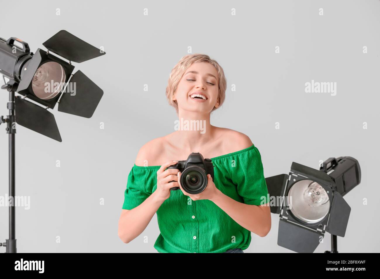 Female photographer with camera in studio Stock Photo - Alamy