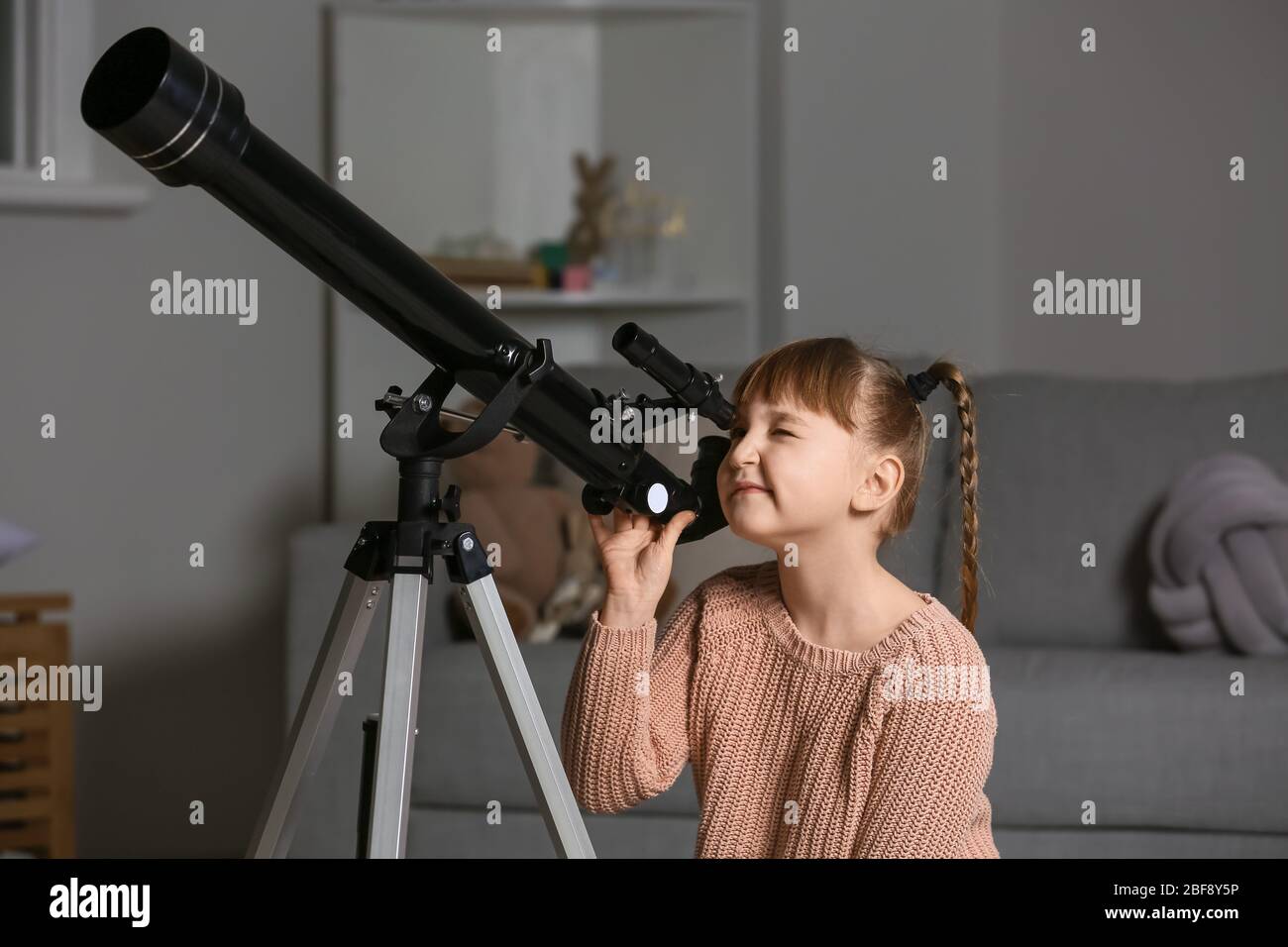 Cute little girl with telescope looking at stars in evening Stock Photo ...