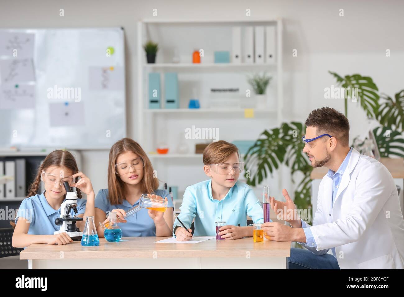 Teacher conducting chemistry lesson in classroom Stock Photo - Alamy
