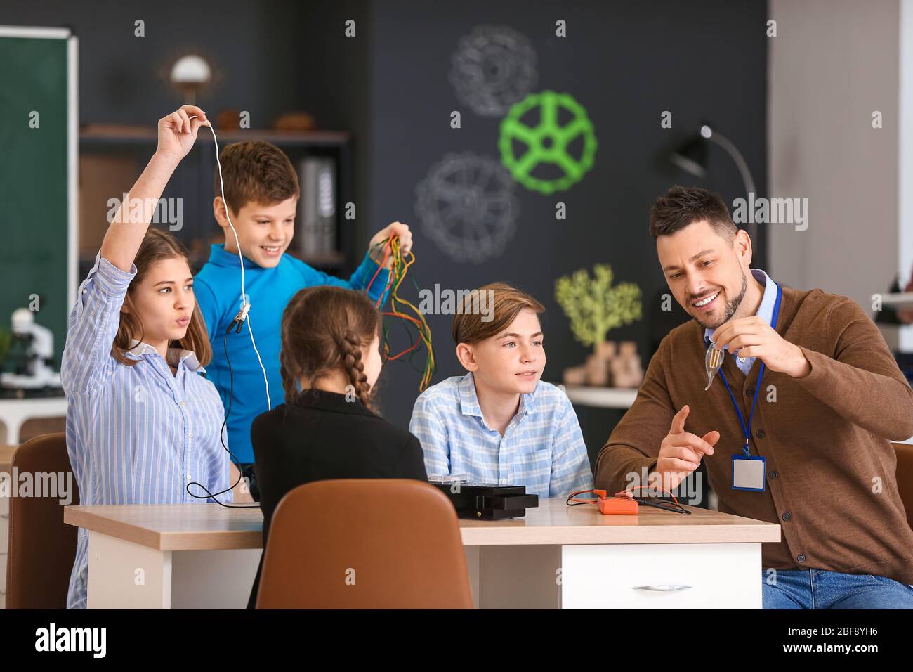 Teacher conducting physics lesson in classroom Stock Photo - Alamy