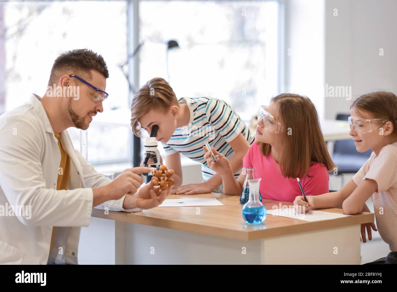 Teacher conducting chemistry lesson in classroom Stock Photo - Alamy