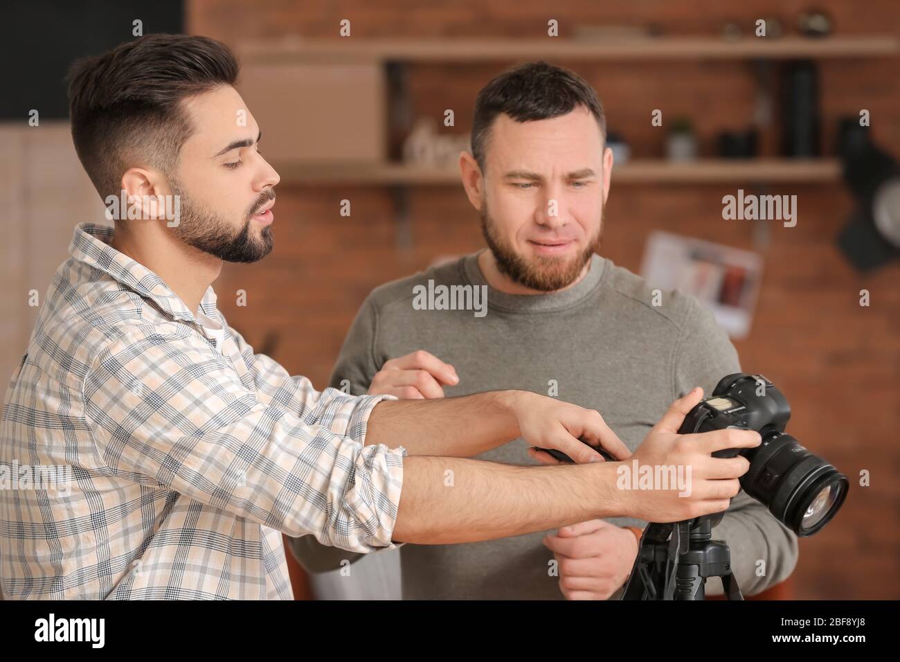Mentor teaching young photographer in studio Stock Photo - Alamy