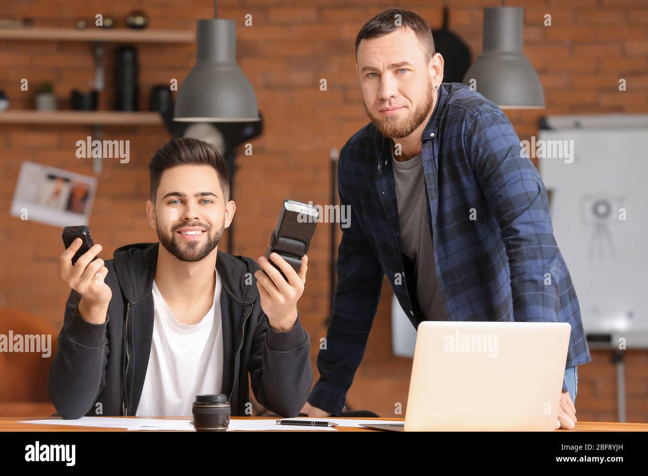 Mentor teaching young photographer in studio Stock Photo - Alamy
