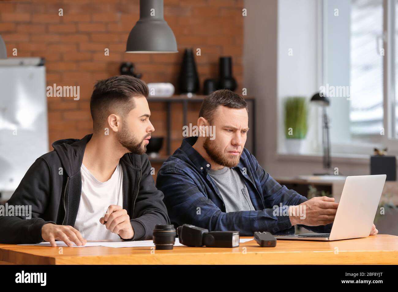 Mentor teaching young photographer in studio Stock Photo - Alamy