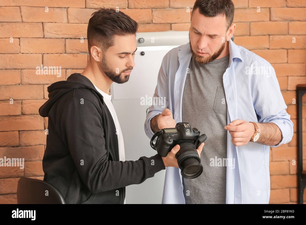 Mentor teaching young photographer in studio Stock Photo - Alamy