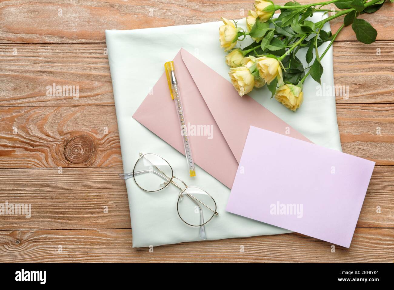 Composition with empty greeting card and envelope on wooden background ...