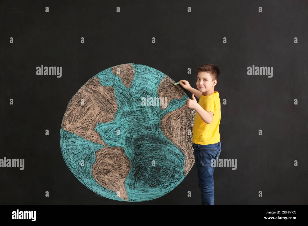 Little boy drawing planet on dark background. Earth Day celebration ...
