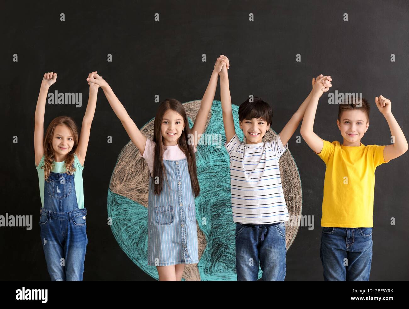Little children and drawing of planet on dark background. Earth Day ...