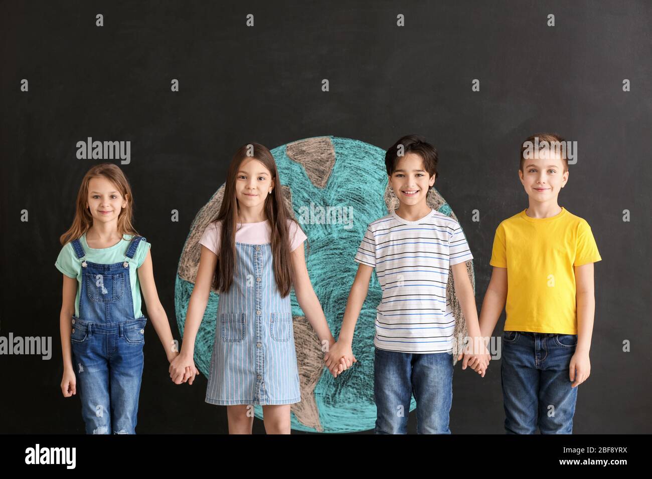 Little children and drawing of planet on dark background. Earth Day ...