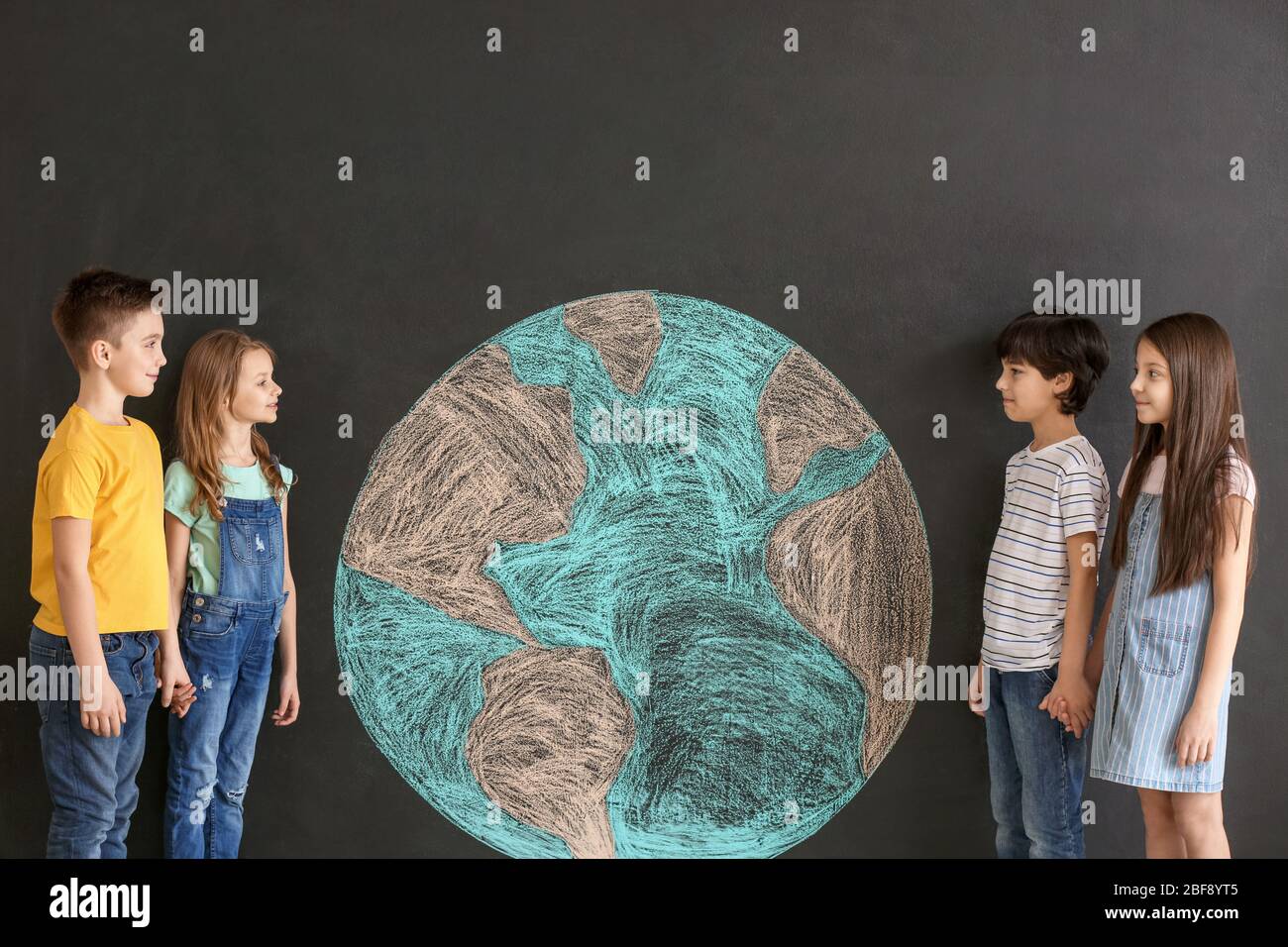 Little children and drawing of planet on dark background. Earth Day ...