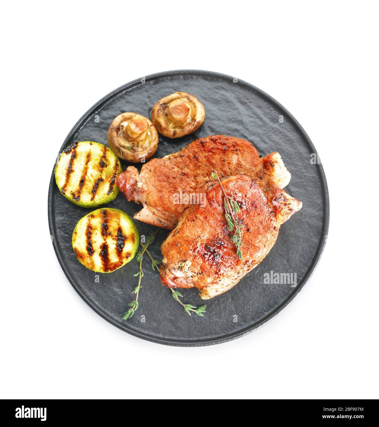 Plate with cooked pork steaks on white background Stock Photo - Alamy