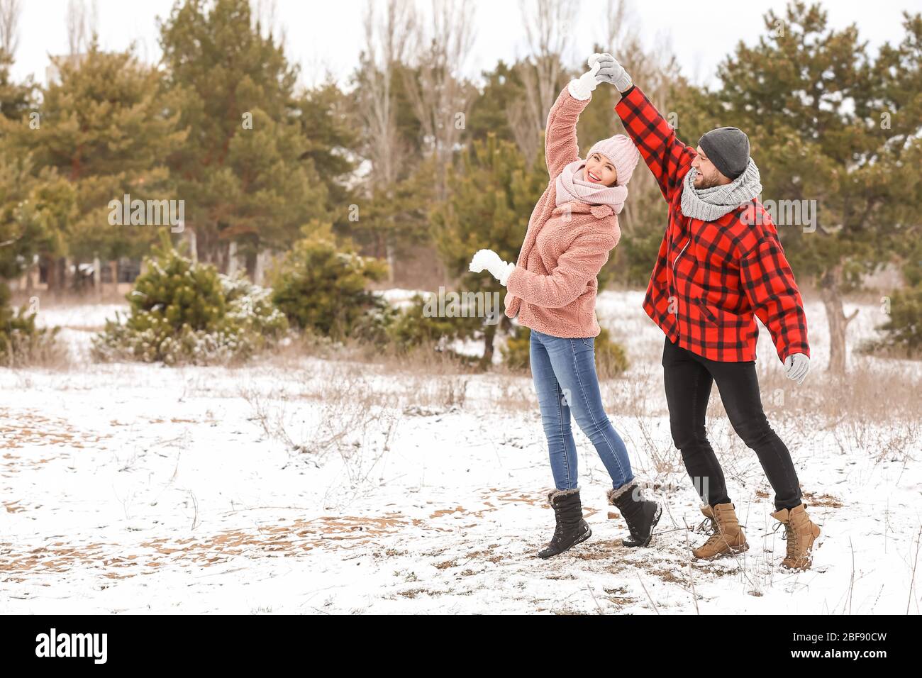 Happy young couple dancing in park on winter day Stock Photo - Alamy