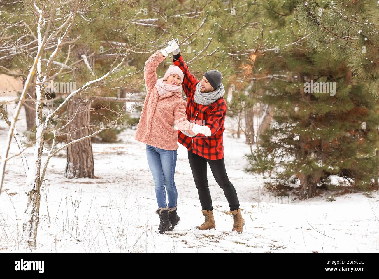 Happy young couple dancing in park on winter day Stock Photo - Alamy