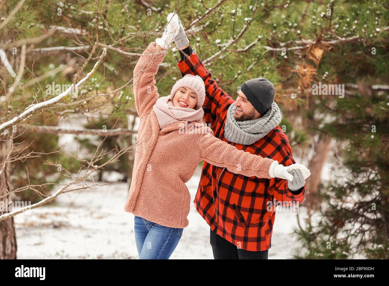 Happy young couple dancing in park on winter day Stock Photo - Alamy