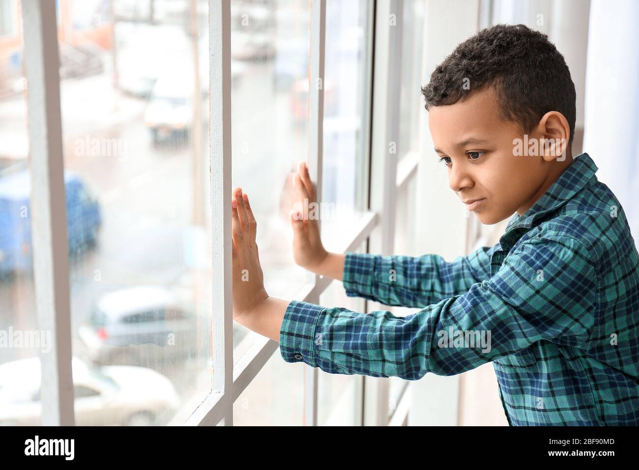 Little African-American boy near window. Child in danger Stock Photo ...