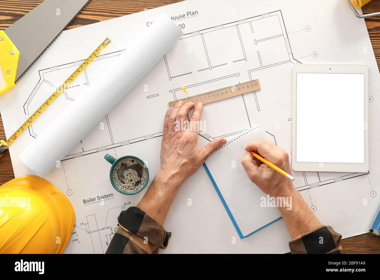 Male builder working with house plan, top view Stock Photo - Alamy