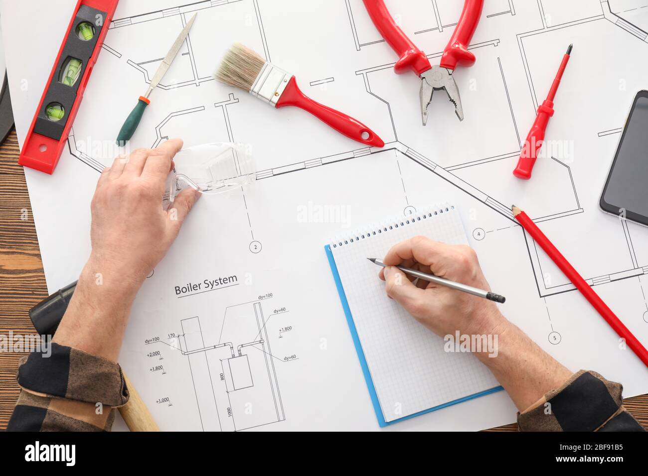 Male builder working with house plan, top view Stock Photo - Alamy