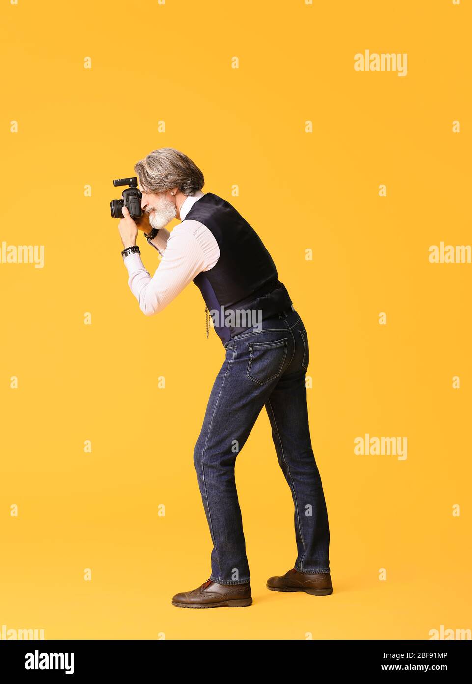 Handsome senior photographer on color background Stock Photo - Alamy