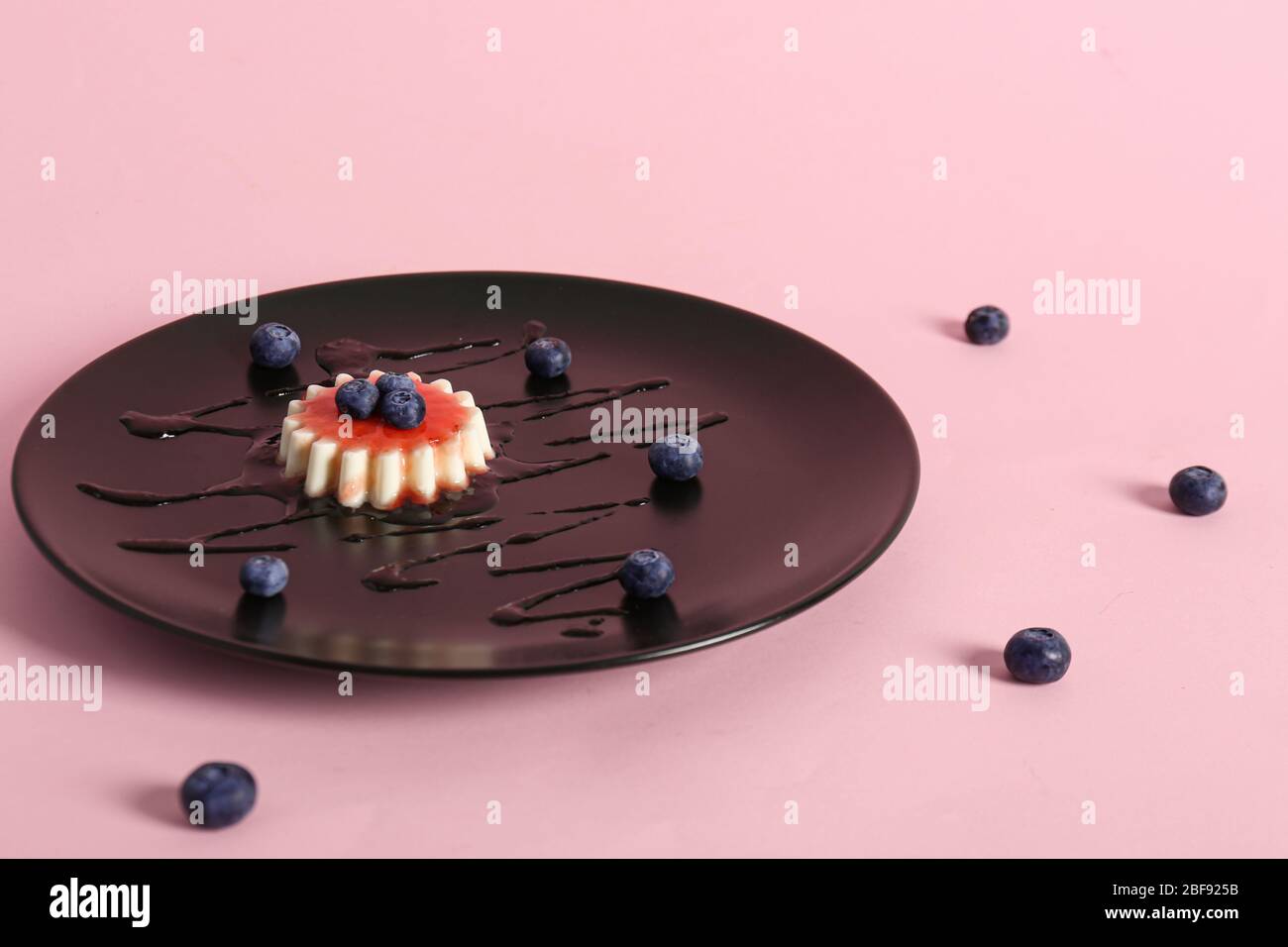 Plate with tasty panna cotta on color background Stock Photo - Alamy