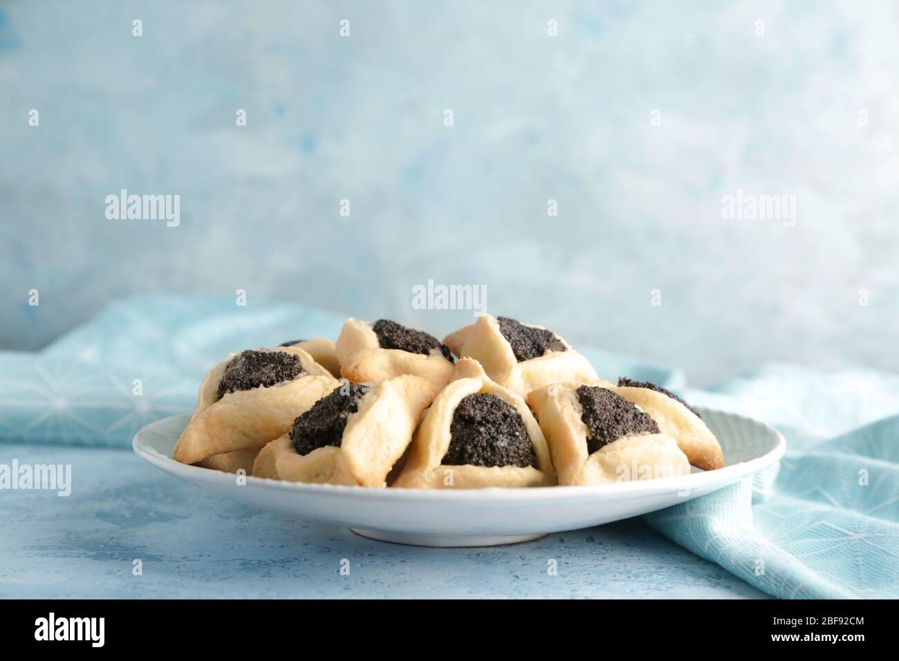 Plate with tasty hamantaschen for Purim holiday on color background ...