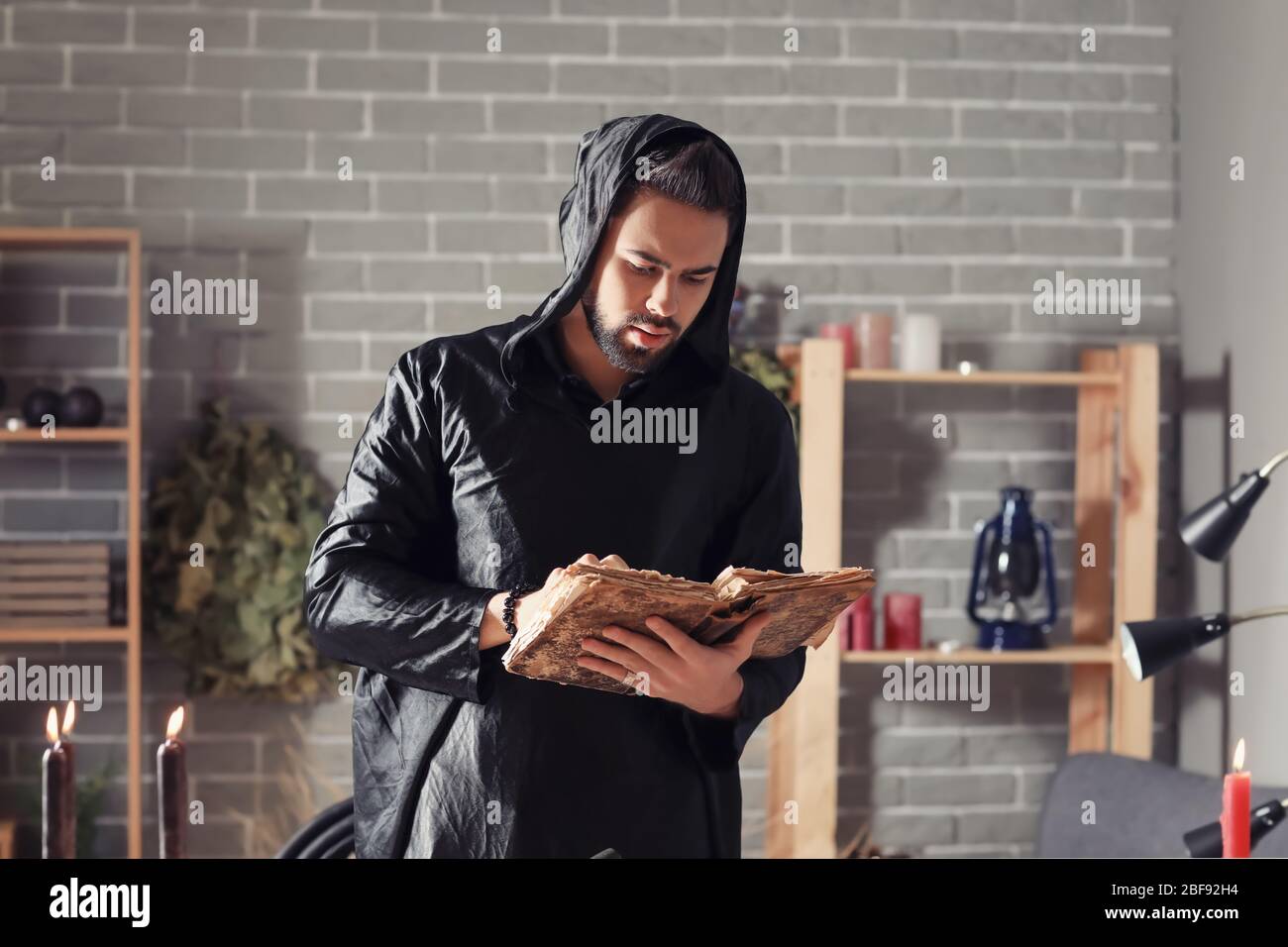 Male alchemist with spell book in laboratory Stock Photo - Alamy