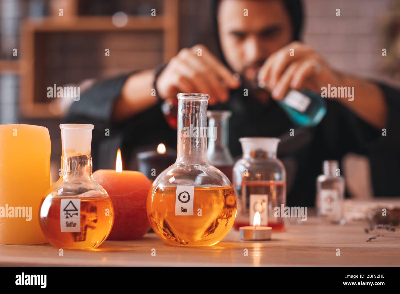 Flasks with potion and candles on table in alchemist's laboratory Stock ...