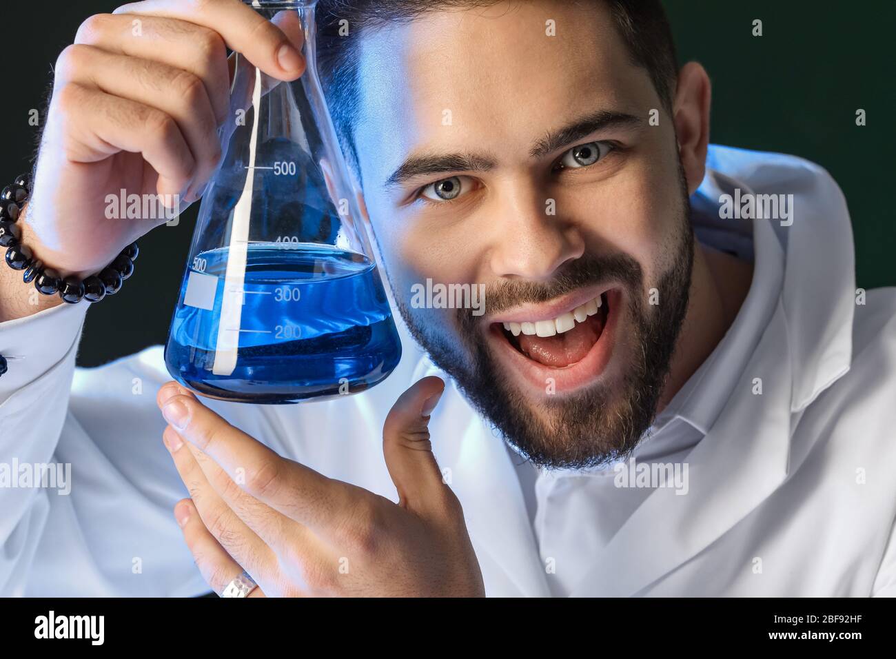 Male alchemist with potion on dark background Stock Photo - Alamy