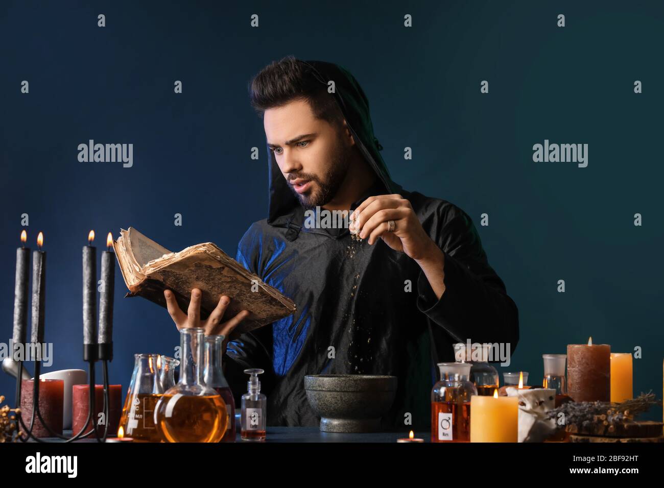 Male alchemist making potion on dark background Stock Photo - Alamy