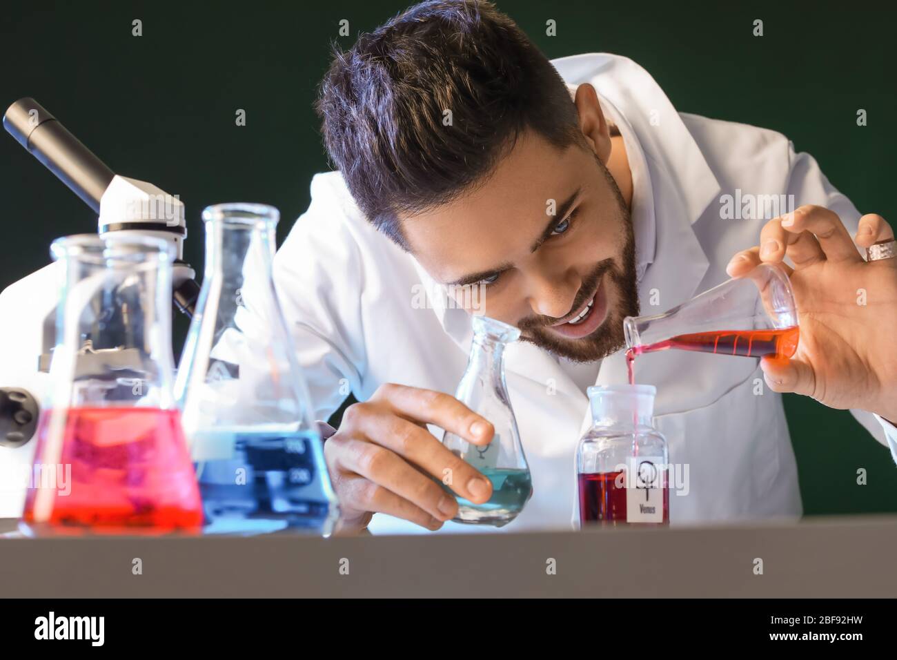 Male alchemist with potions at table Stock Photo - Alamy
