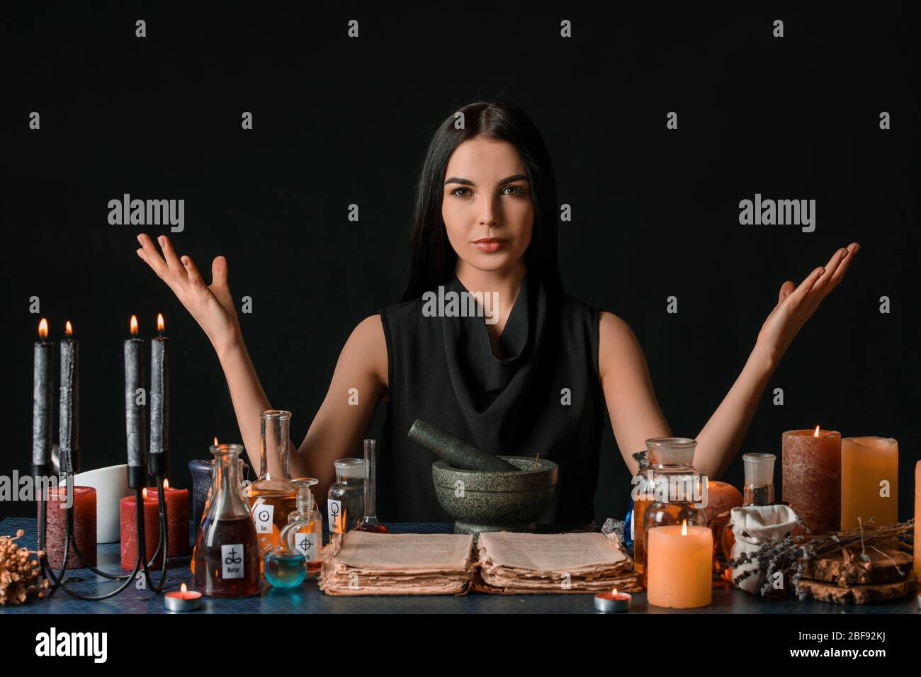 Female alchemist making potion on dark background Stock Photo - Alamy