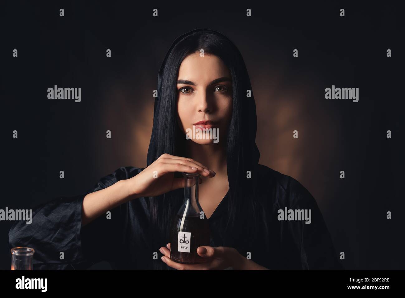 Female alchemist with potion on dark background Stock Photo - Alamy