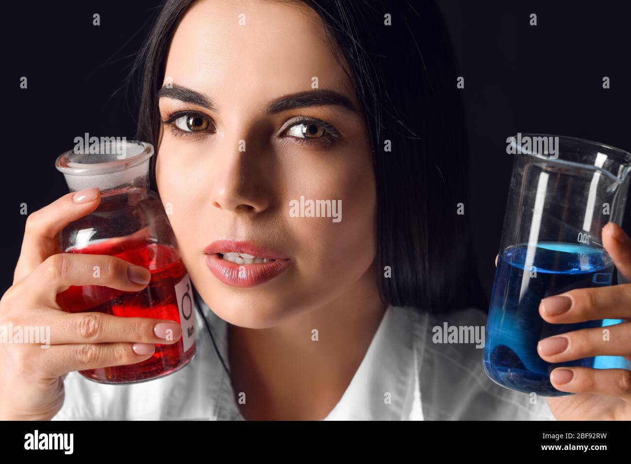 Female alchemist with potions on dark background Stock Photo - Alamy