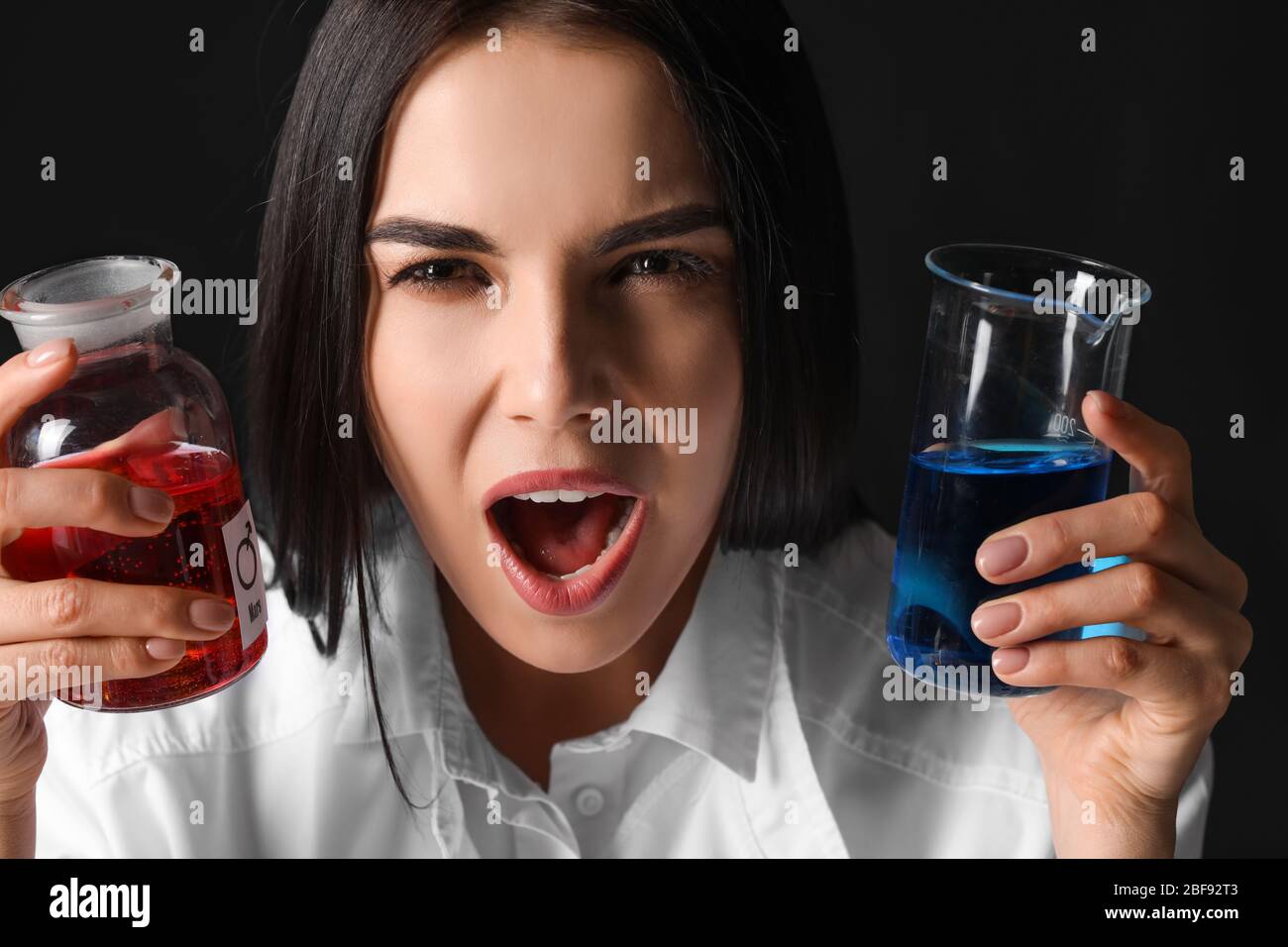 Female alchemist with potions on dark background Stock Photo - Alamy