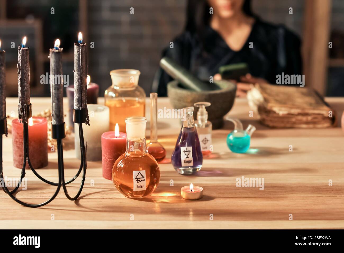 Bottles with potions and candles on table of alchemist Stock Photo - Alamy