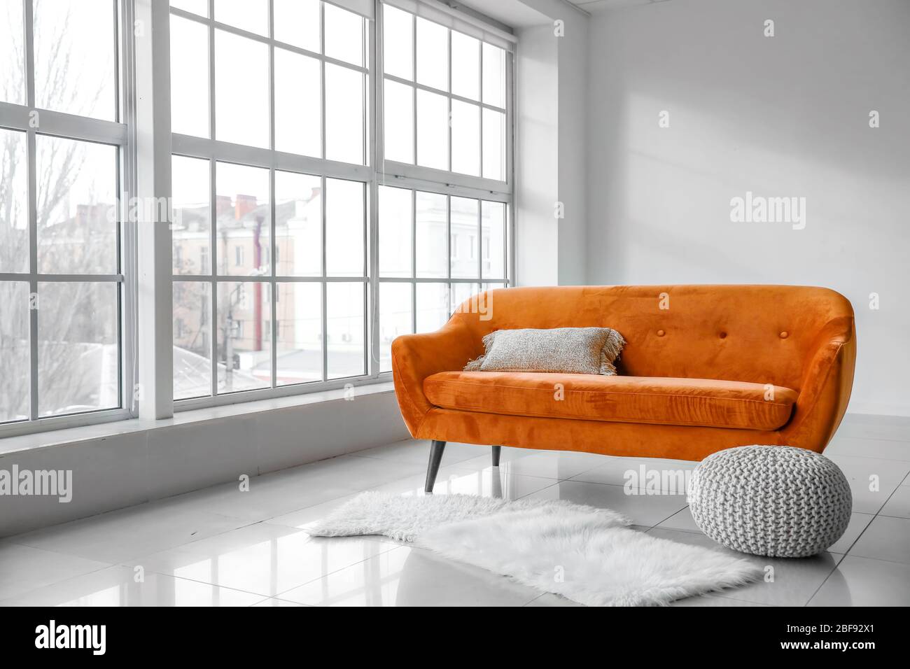 Comfortable sofa near window in room Stock Photo - Alamy