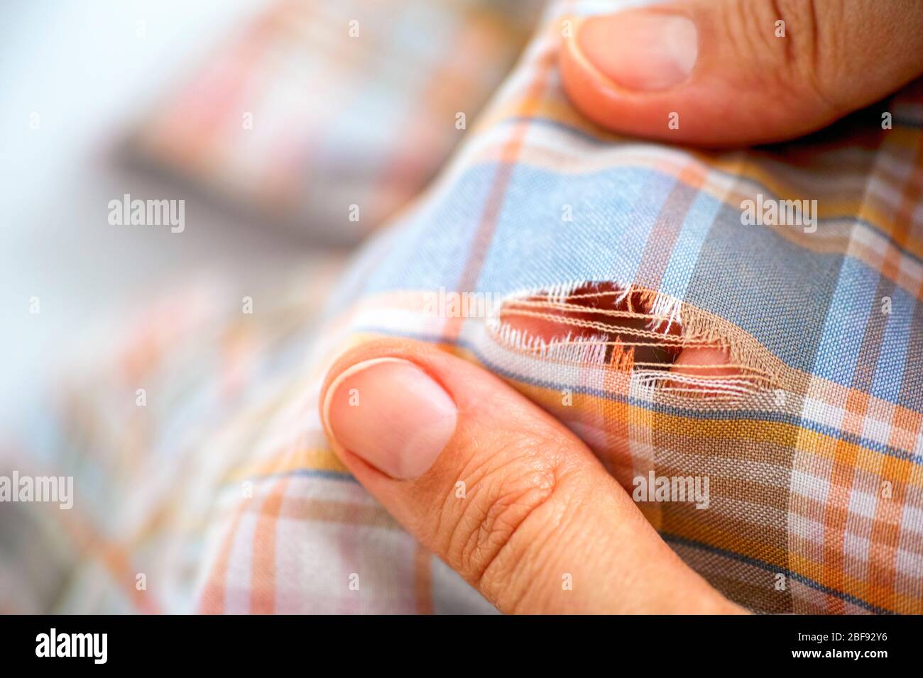 Woman hands showing hole in clothes. Close-up Stock Photo - Alamy