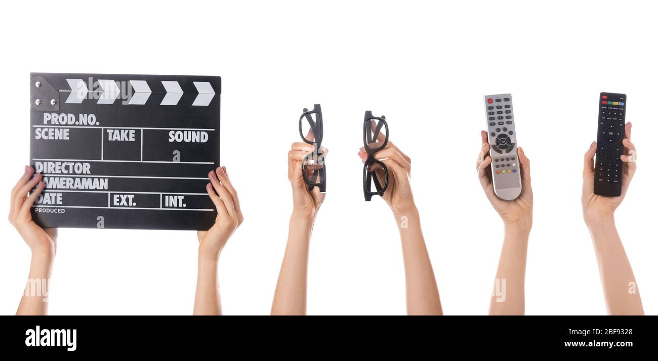 Many hands with movie clapper with eyeglasses and remote controls on ...