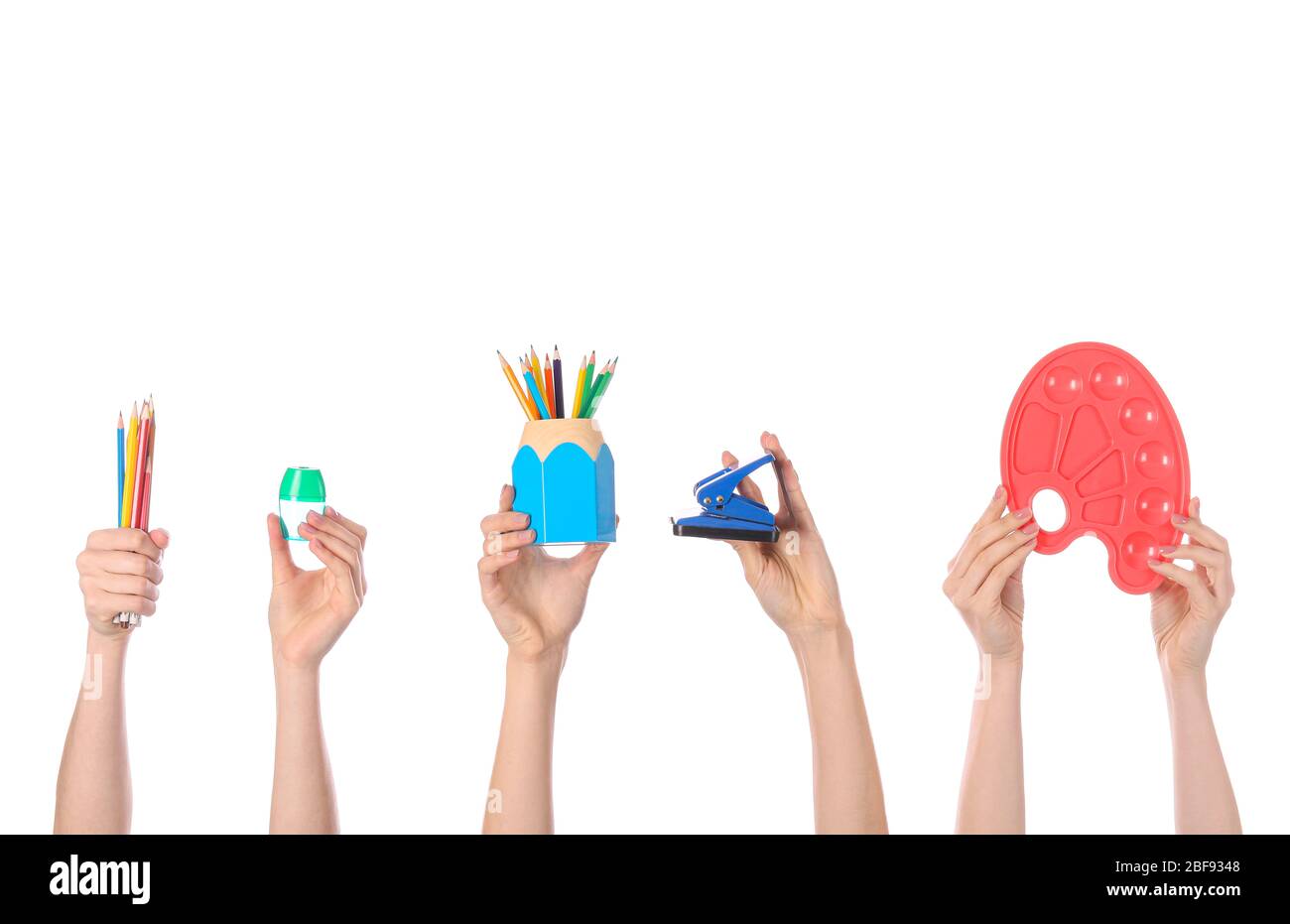 Many hands with school supplies on white background Stock Photo - Alamy