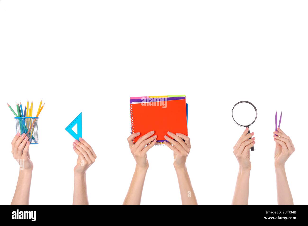 Many hands with school supplies on white background Stock Photo - Alamy