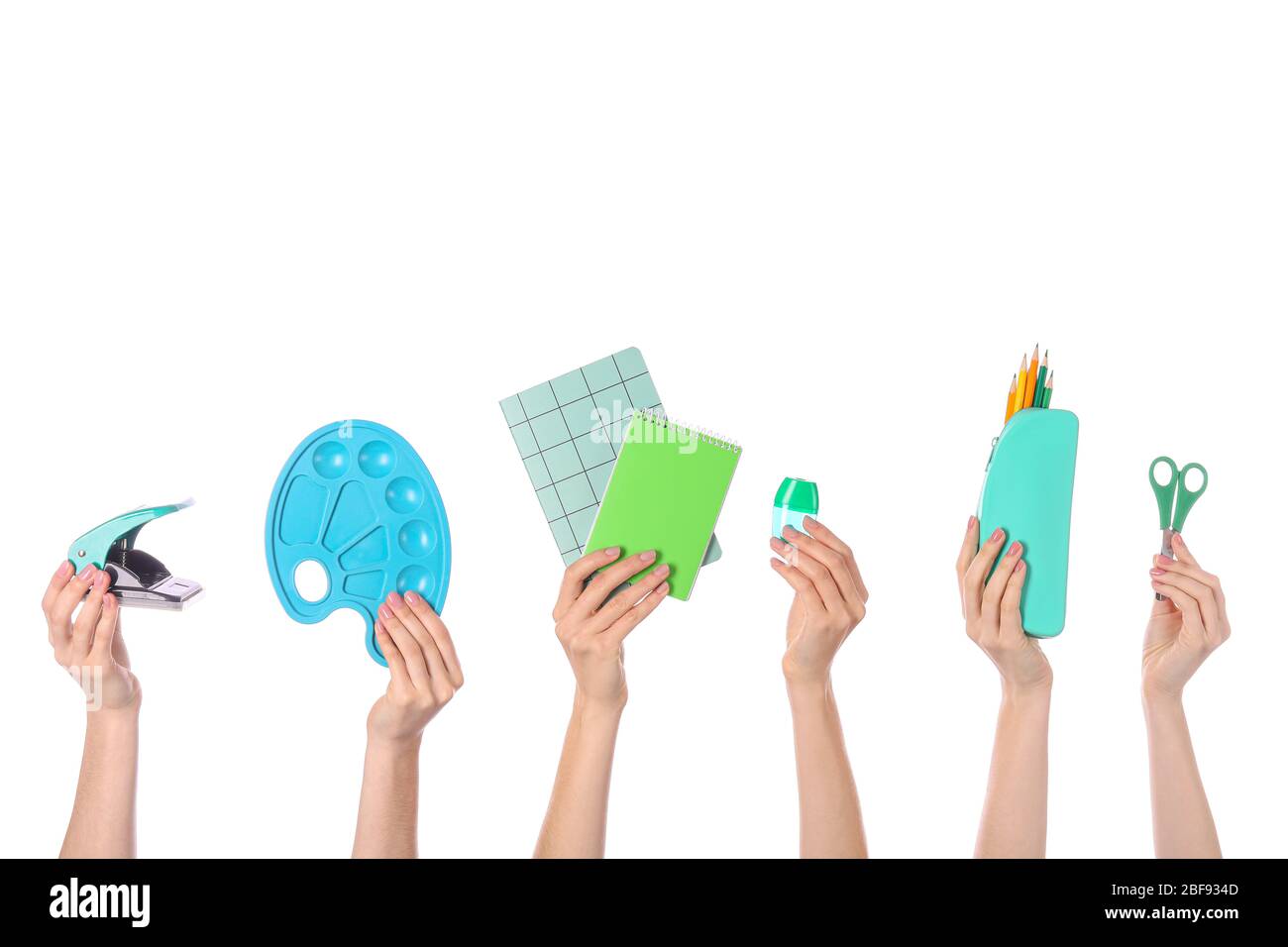 Many hands with school supplies on white background Stock Photo - Alamy