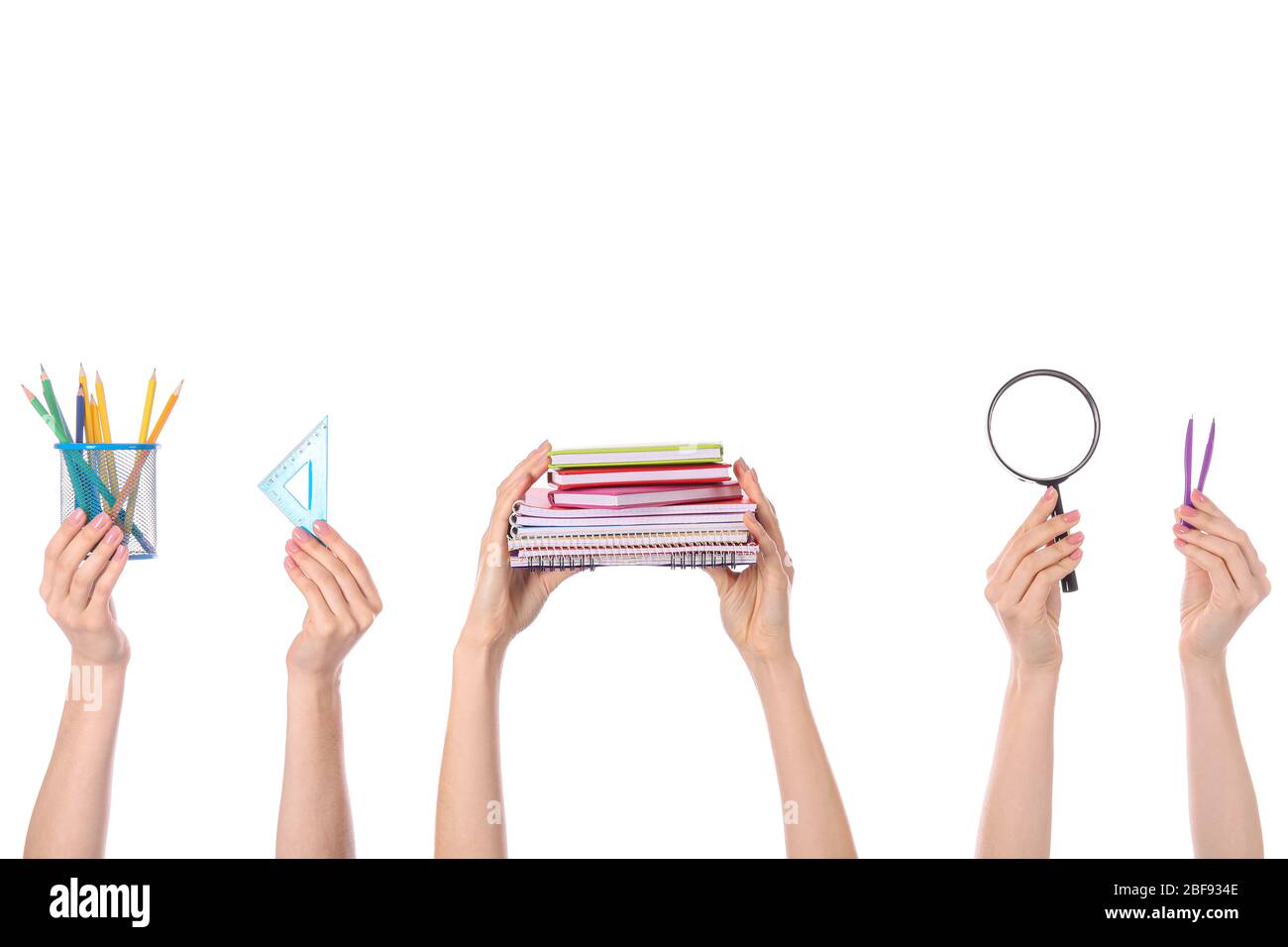 Many hands with school supplies on white background Stock Photo - Alamy