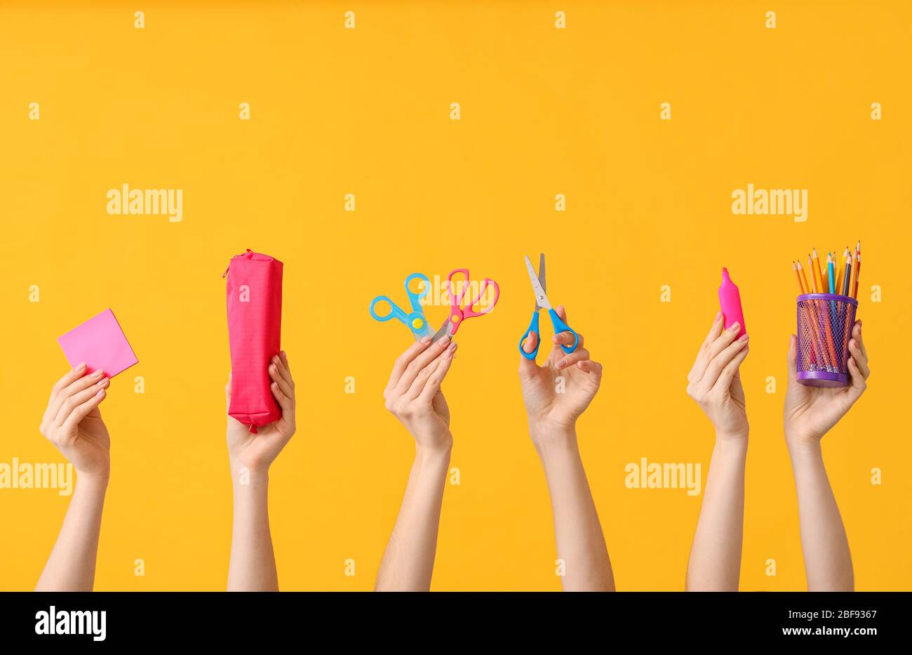 Many hands with school supplies on color background Stock Photo - Alamy