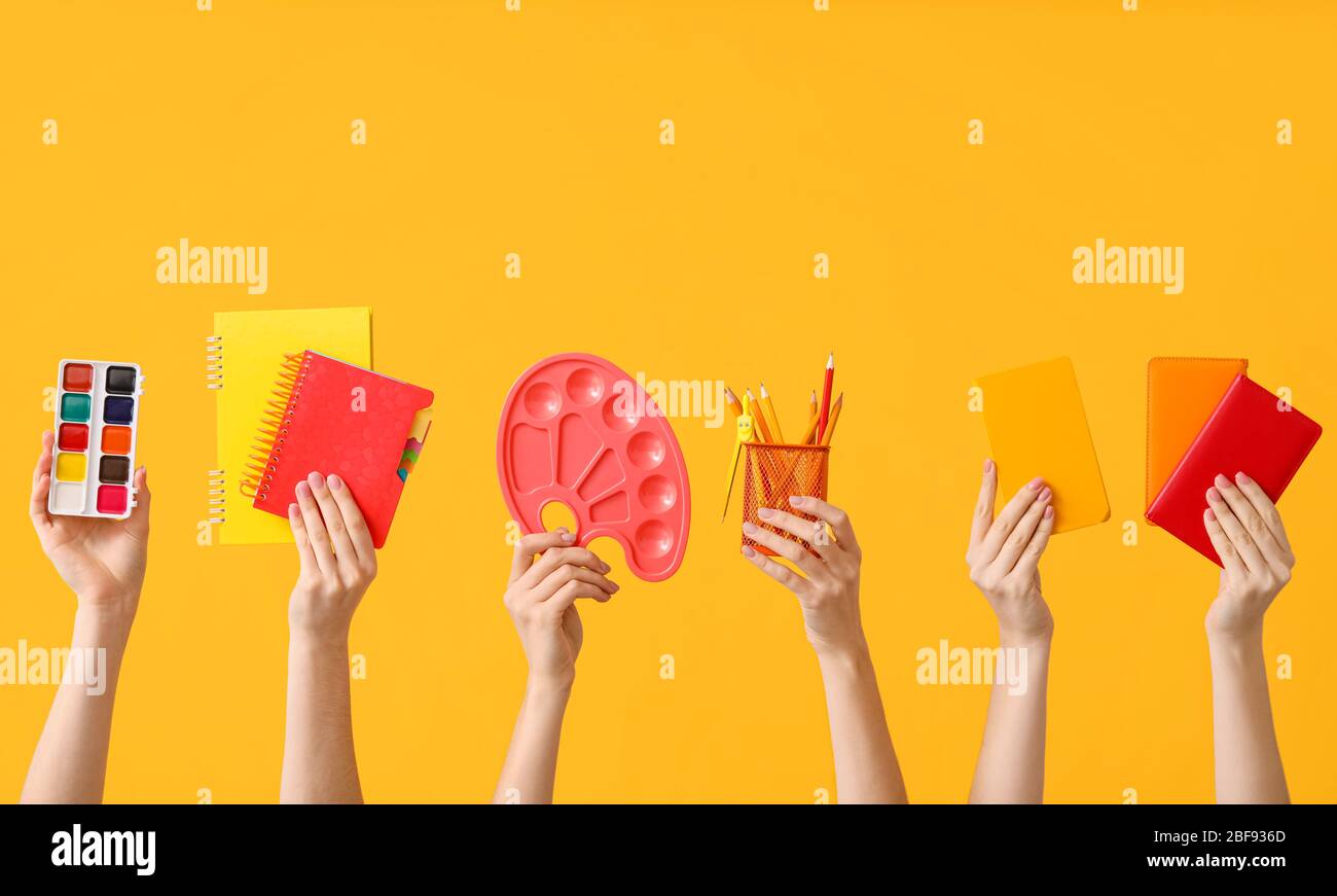 Many hands with school supplies on color background Stock Photo - Alamy