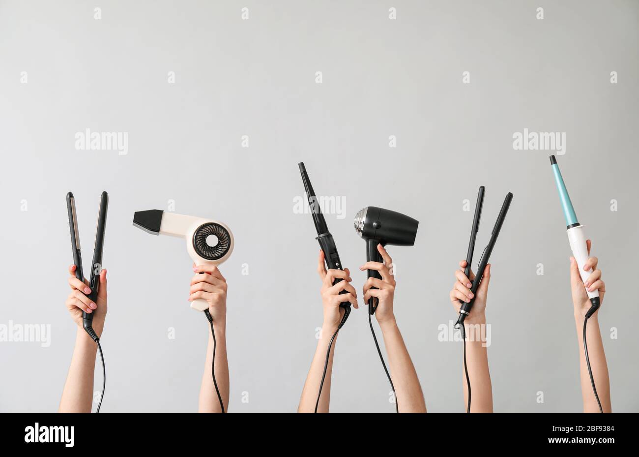 Many hands with hairdresser's devices on grey background Stock Photo ...