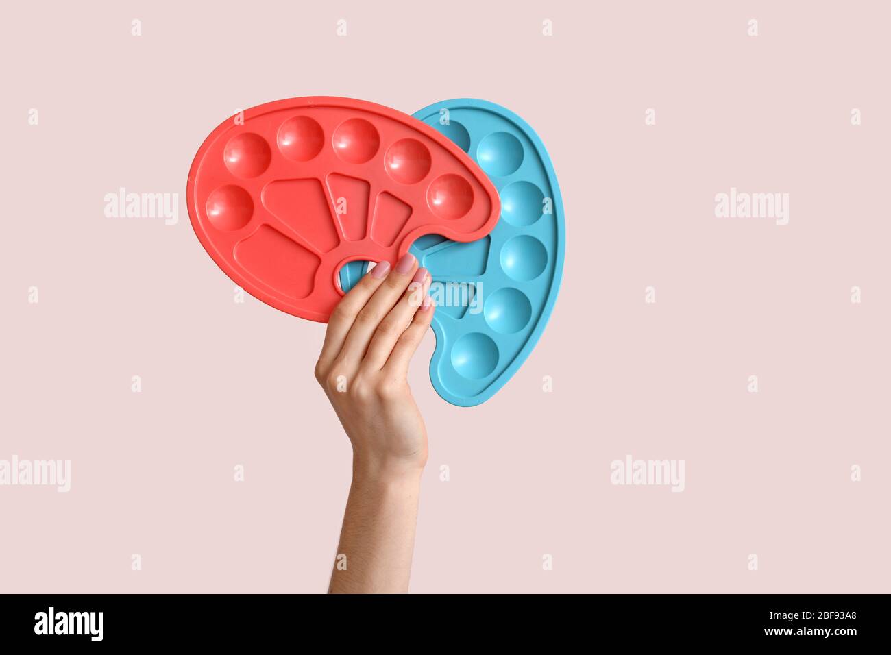 Hand with paint palettes on light background Stock Photo - Alamy