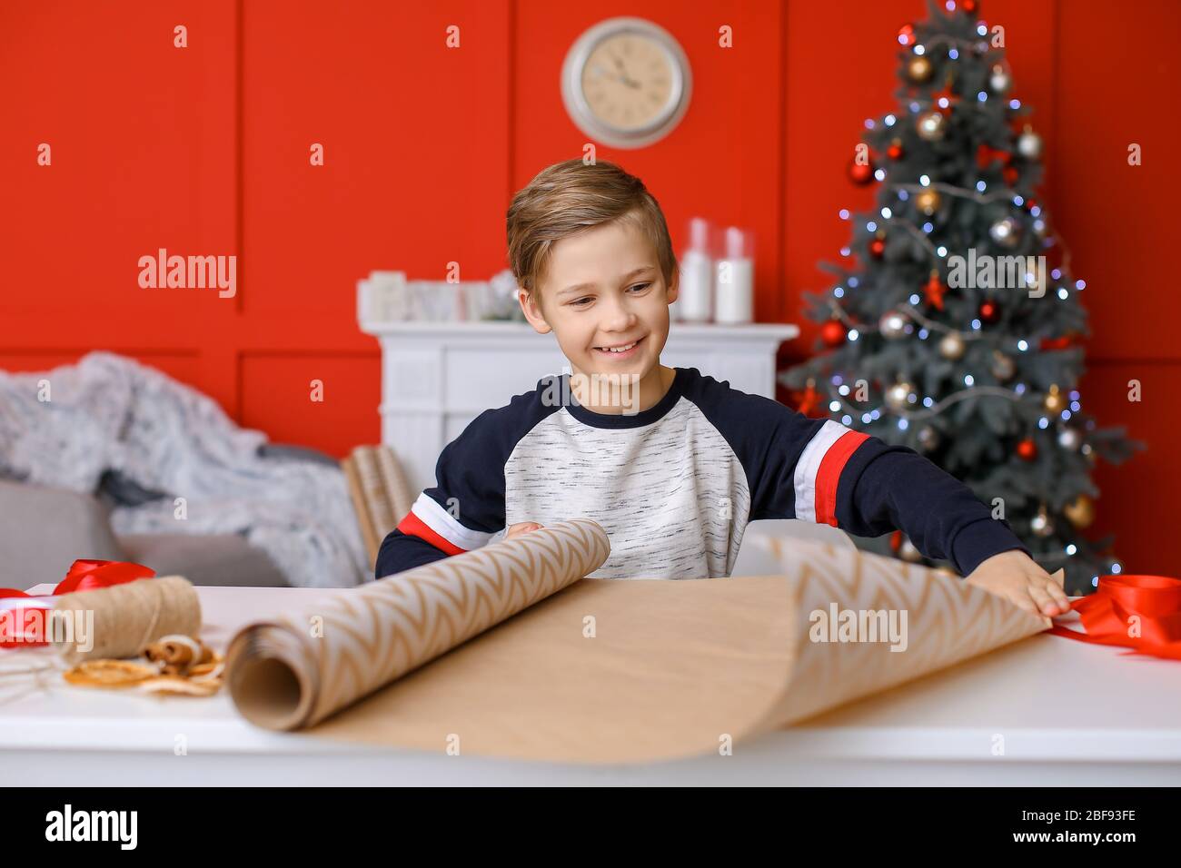 Little boy wrapping Christmas gift at home Stock Photo - Alamy