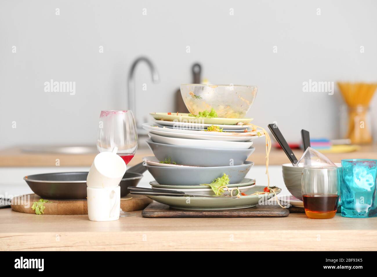 Pile of dirty dishes on kitchen table Stock Photo - Alamy