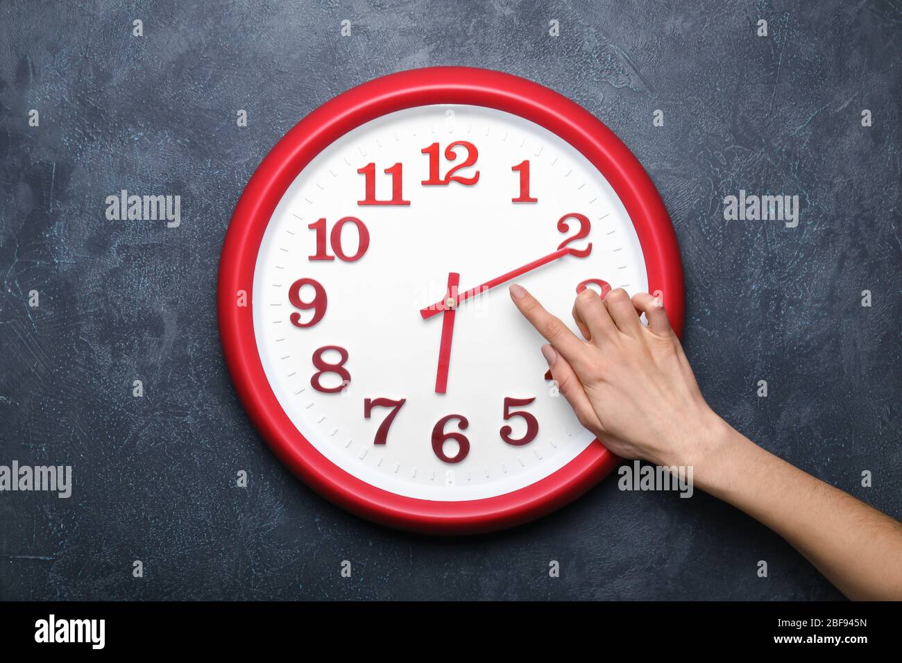 Female hand with clock on dark background. Time management concept ...