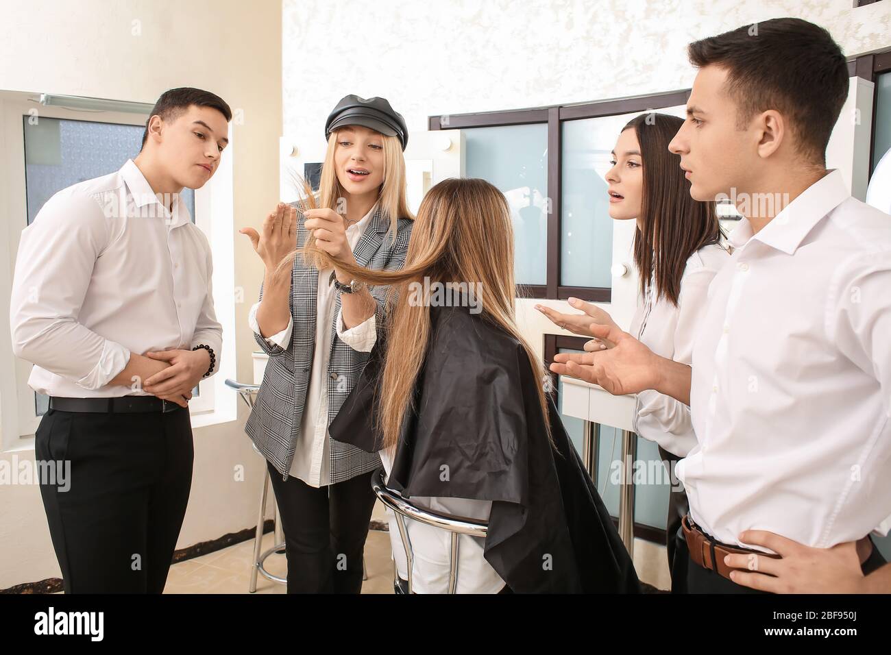 Professional hairdresser teaching young people in salon Stock Photo - Alamy